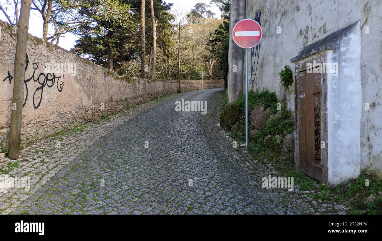 A road sign prohibiting traffic on a road made of paving stones, stone ...