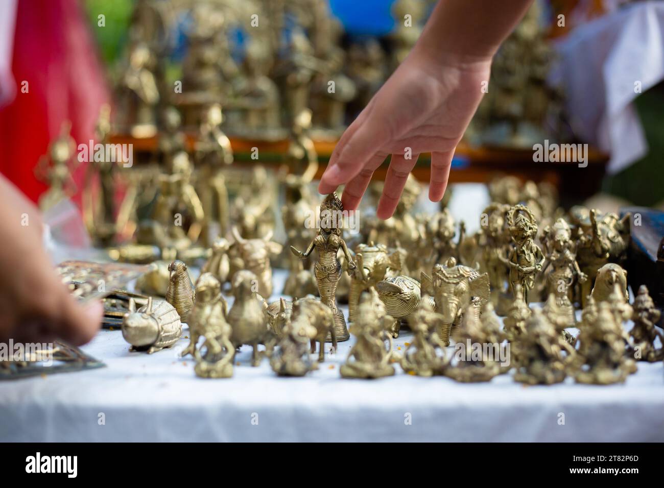 A human hand touching handmade bronze items in a roadside shop Stock ...