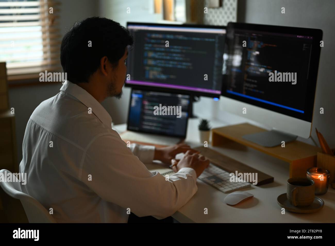 Skilled male programmer working with coded data on computer screen in dark room Stock Photo - Alamy