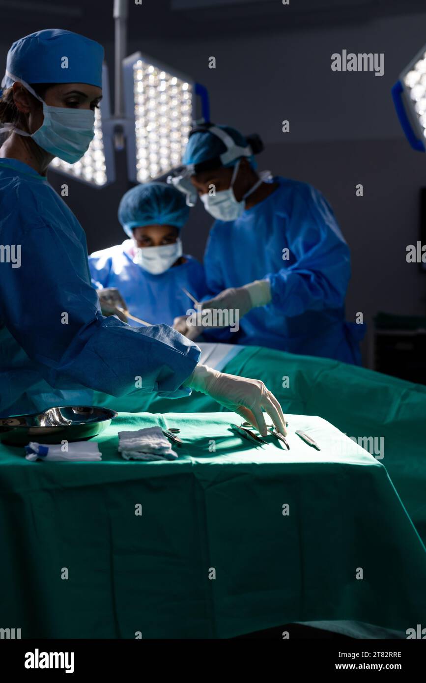 Diverse female doctors with face masks doing surgery in hospital ...