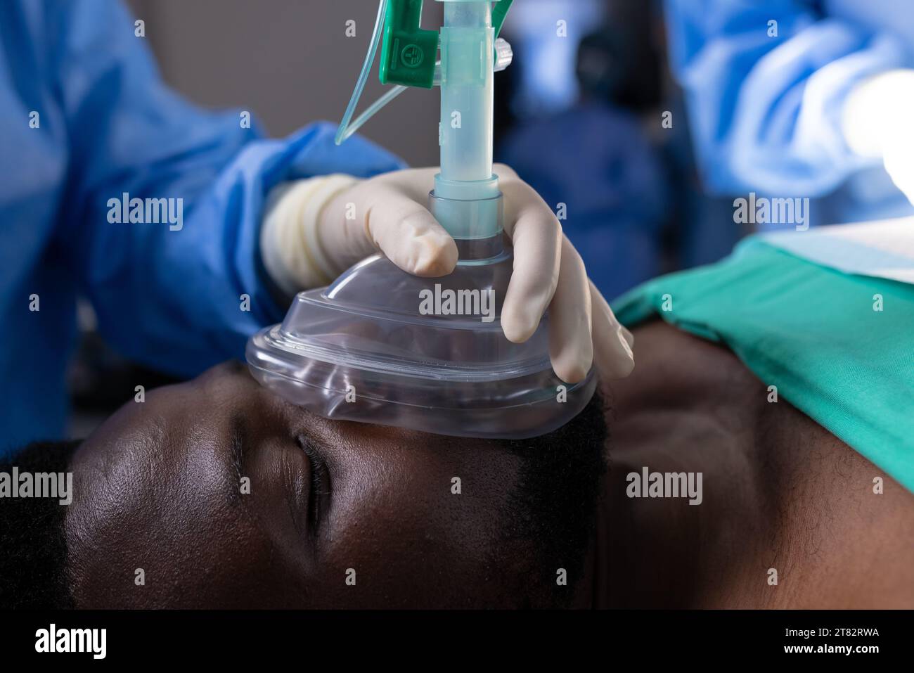 Asian female doctor with face mask holding oxygen mask on patient face ...