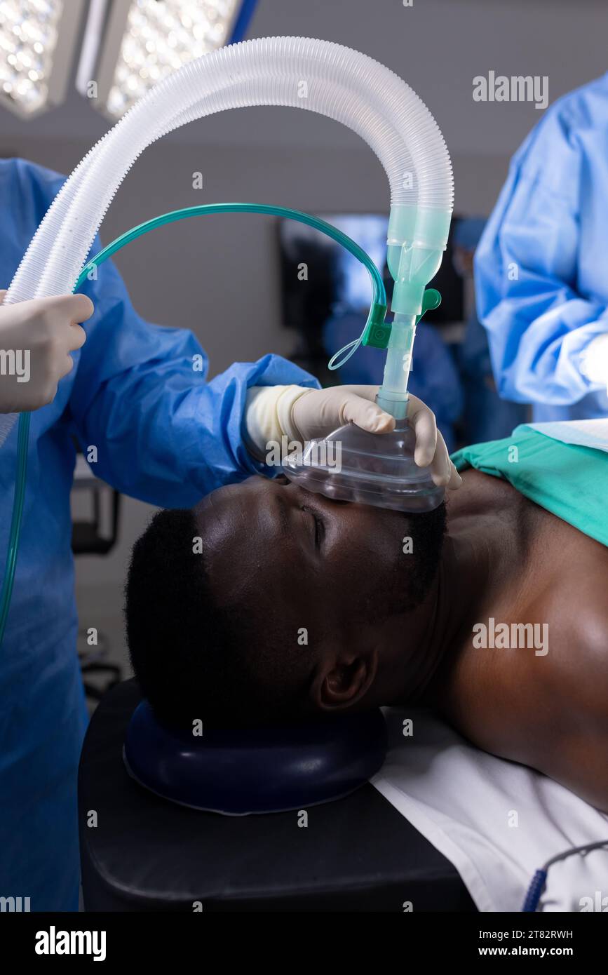 Asian female doctor with face mask holding oxygen mask on patient face ...