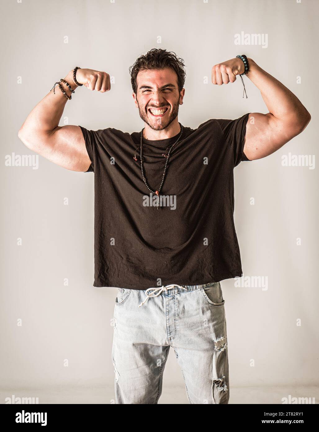 A Confident Man Doing a Double Biceps Pose, Smiling to the Camera, on ...