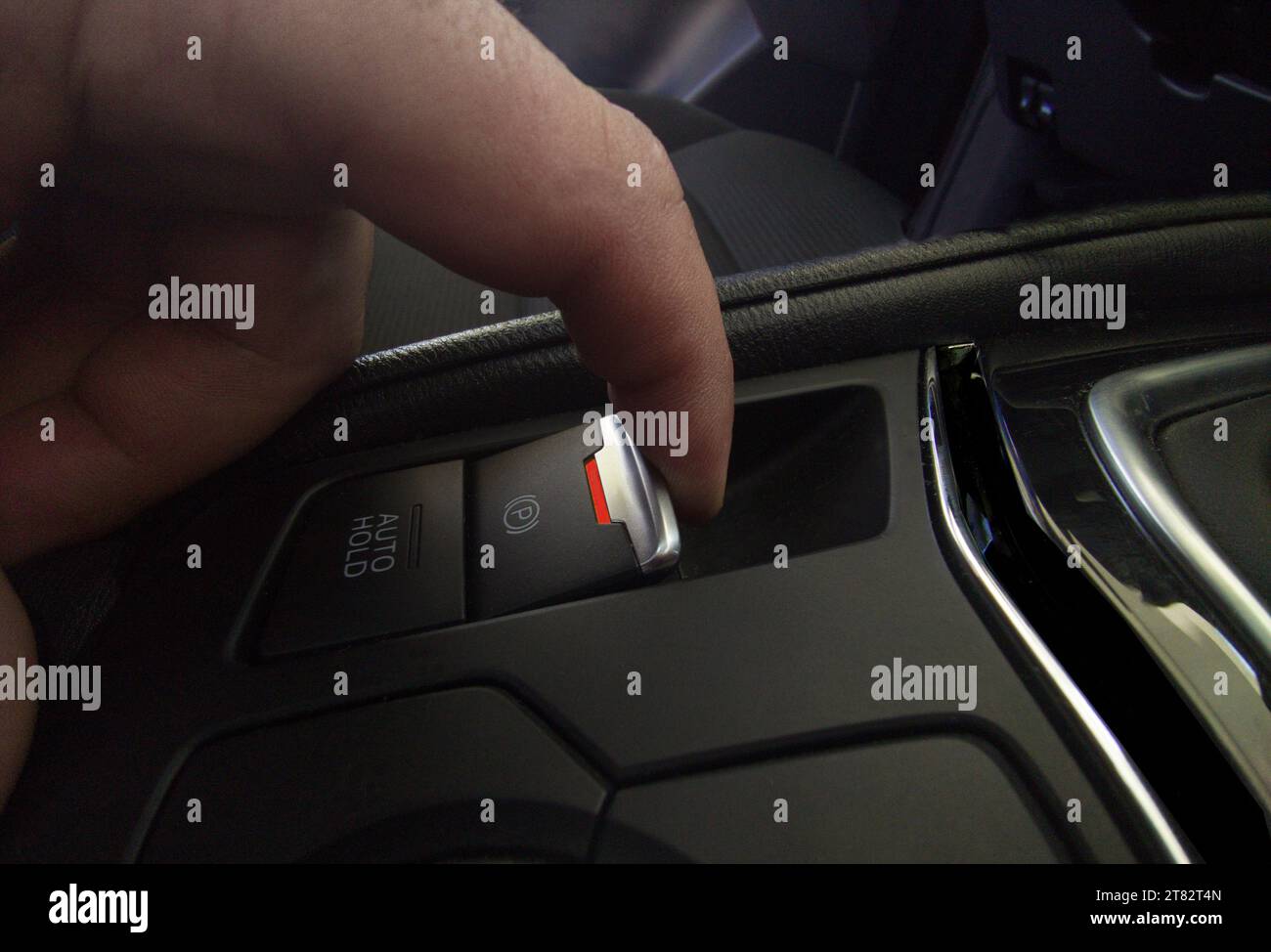 Driver pulling the electric parking brake of his car. Red color light ...