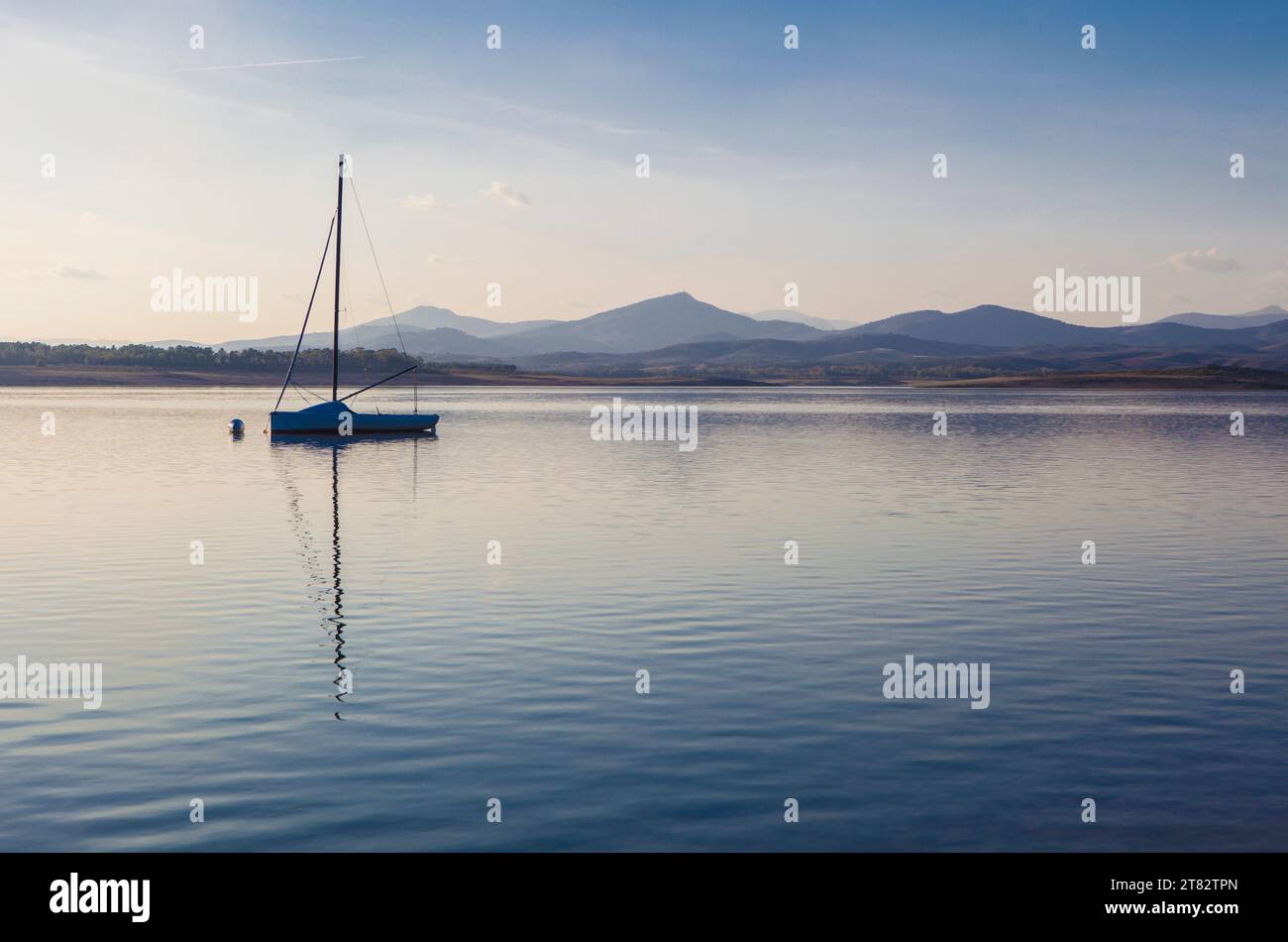 Sailing boat anchored on the shore of the Gabriel y Galan reservoir ...