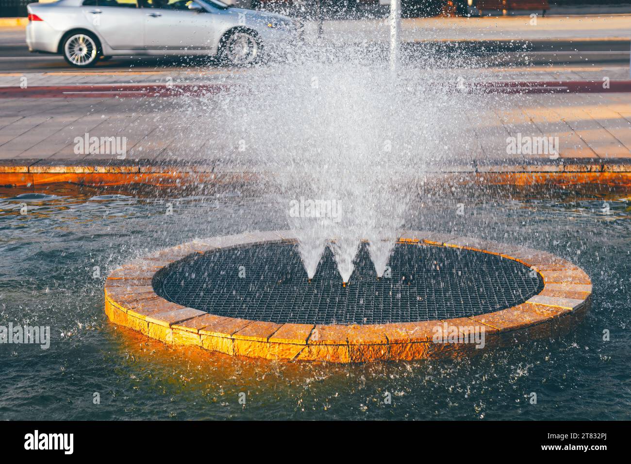 City street fountain featuring a mesh structure, where water gracefully ...