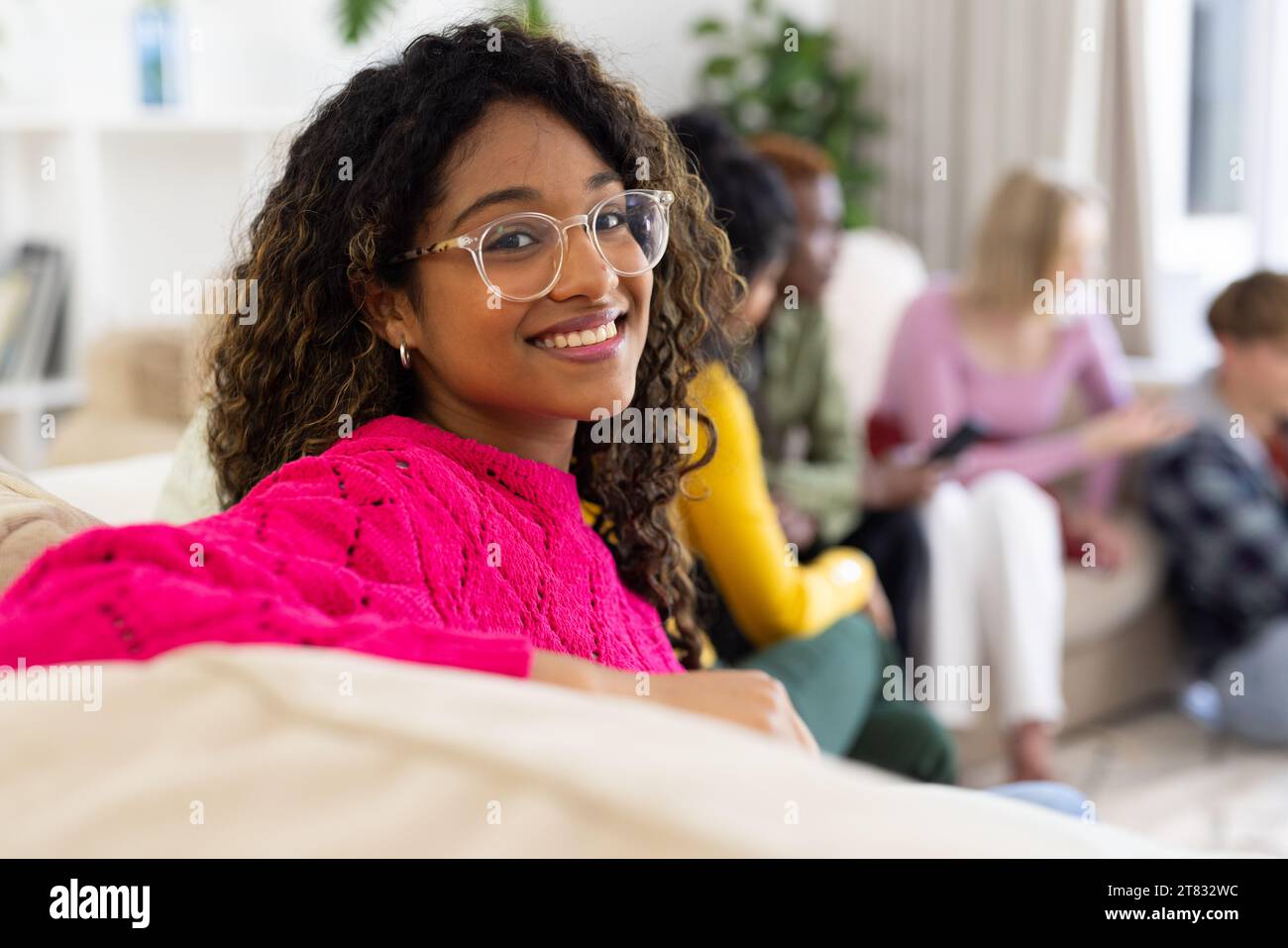 Portrait of happy diverse group of teenage friends talking at home ...