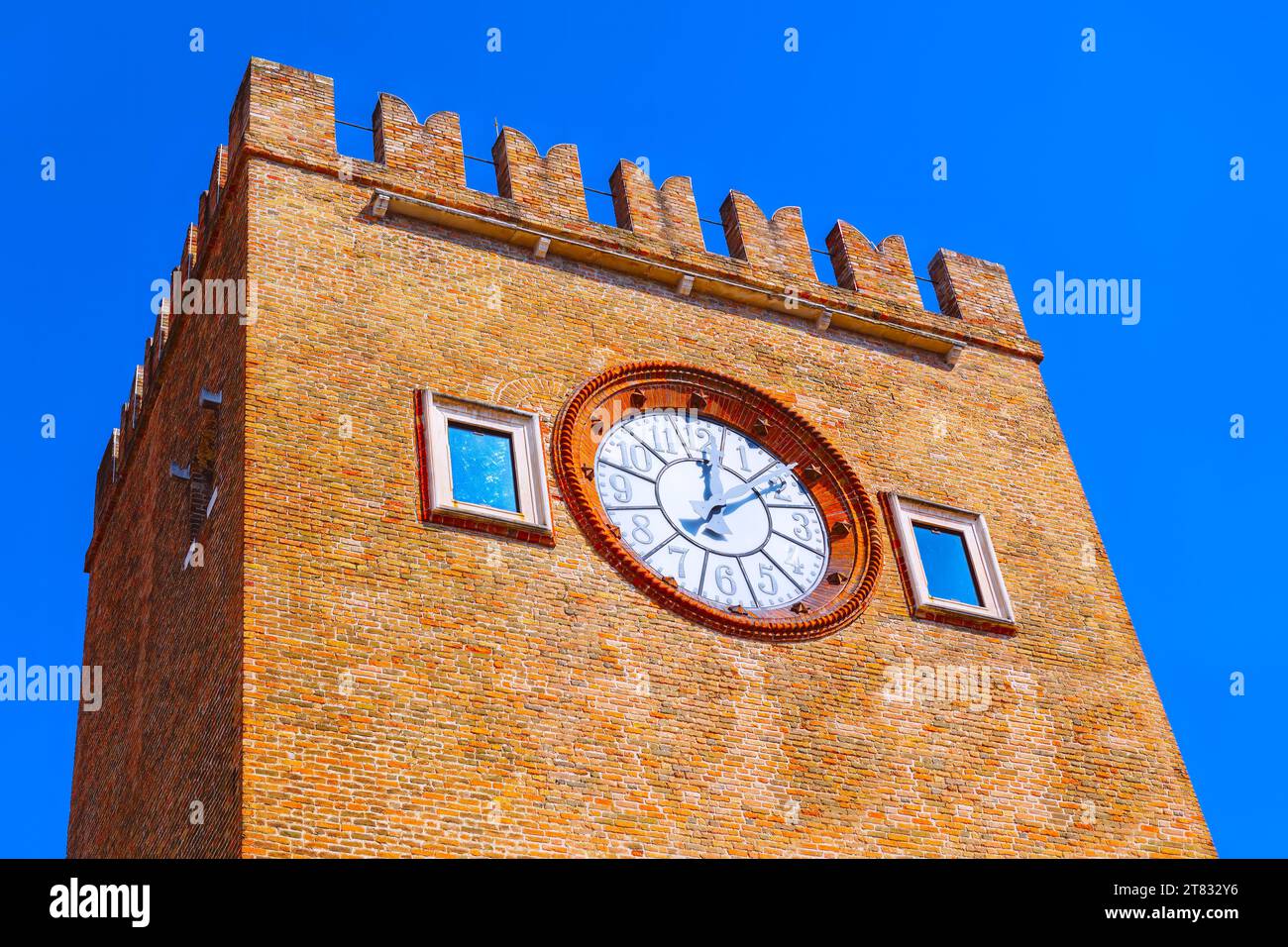 Venetian style tower made by red bricks with iconic clock Stock Photo ...