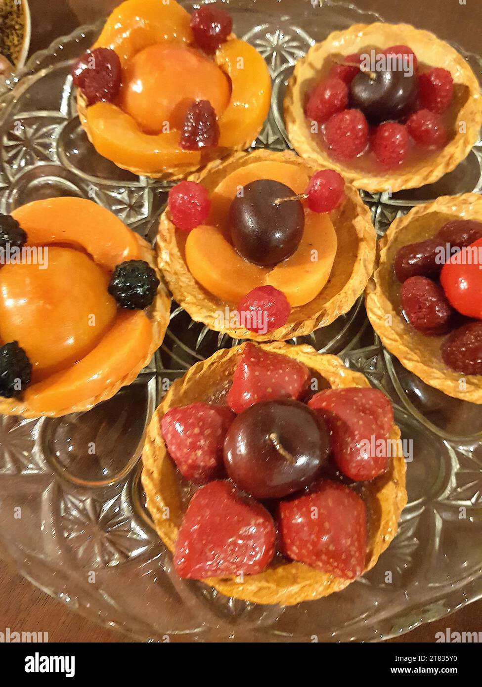 Close up of a display of fruit tarts on a glass plate Stock Photo - Alamy