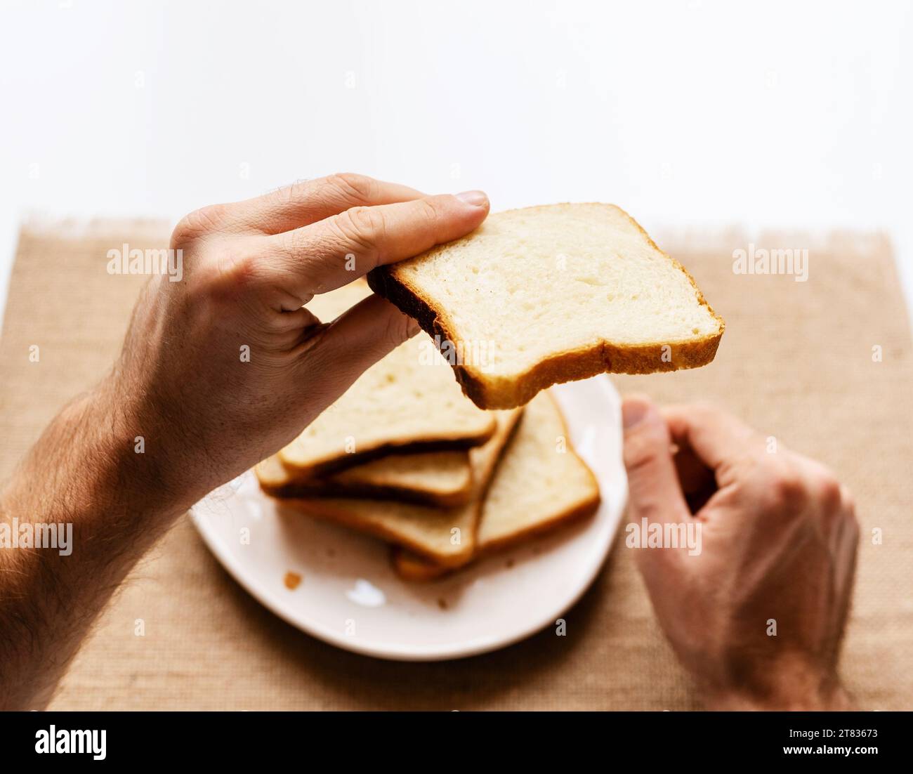 Slice of sandwich bread in male hand Stock Photo - Alamy