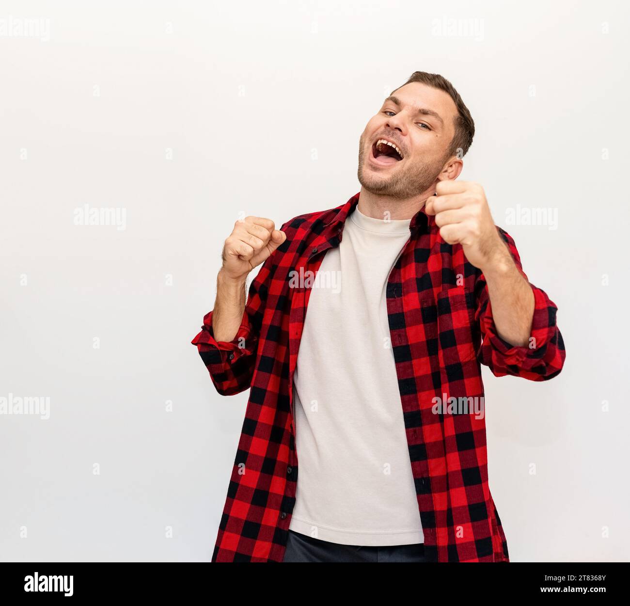 Isolated man rejoicing with clenched fists in front of white background ...