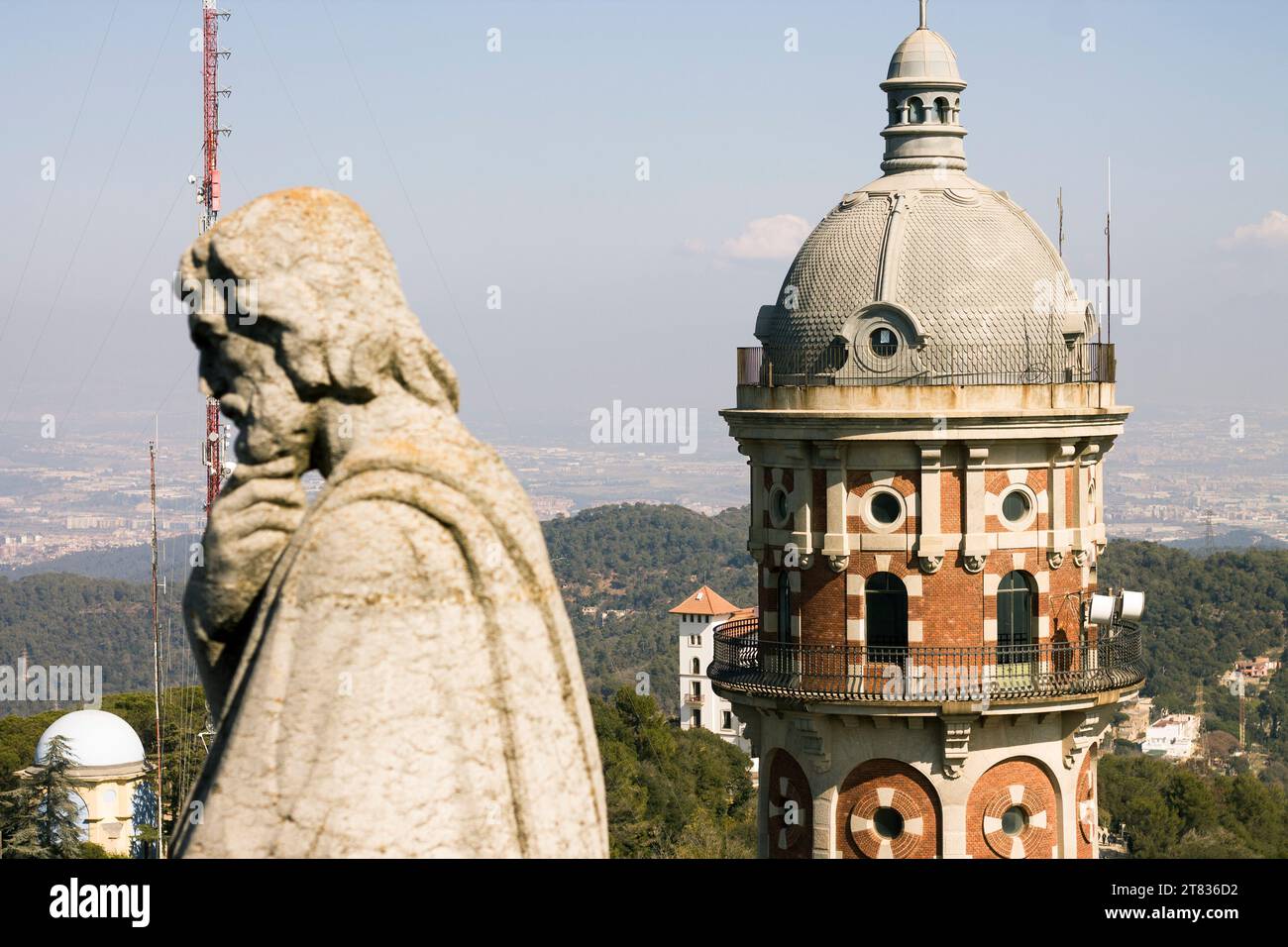 A bronze statue of a classical figure stands in a public square, beside ...