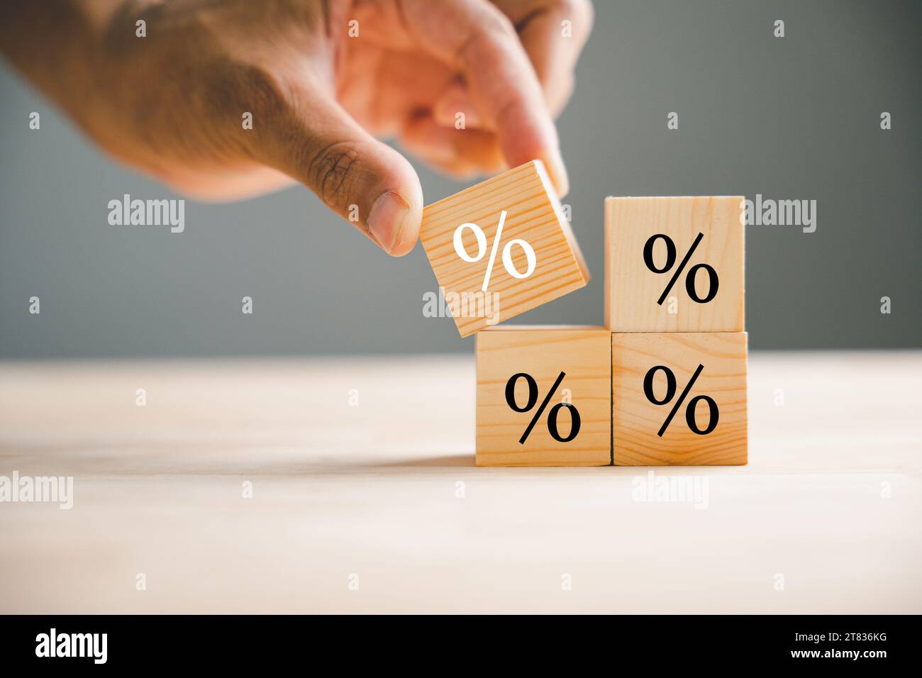 Businessman's hand arranging a wood cube block with a percentage symbol ...