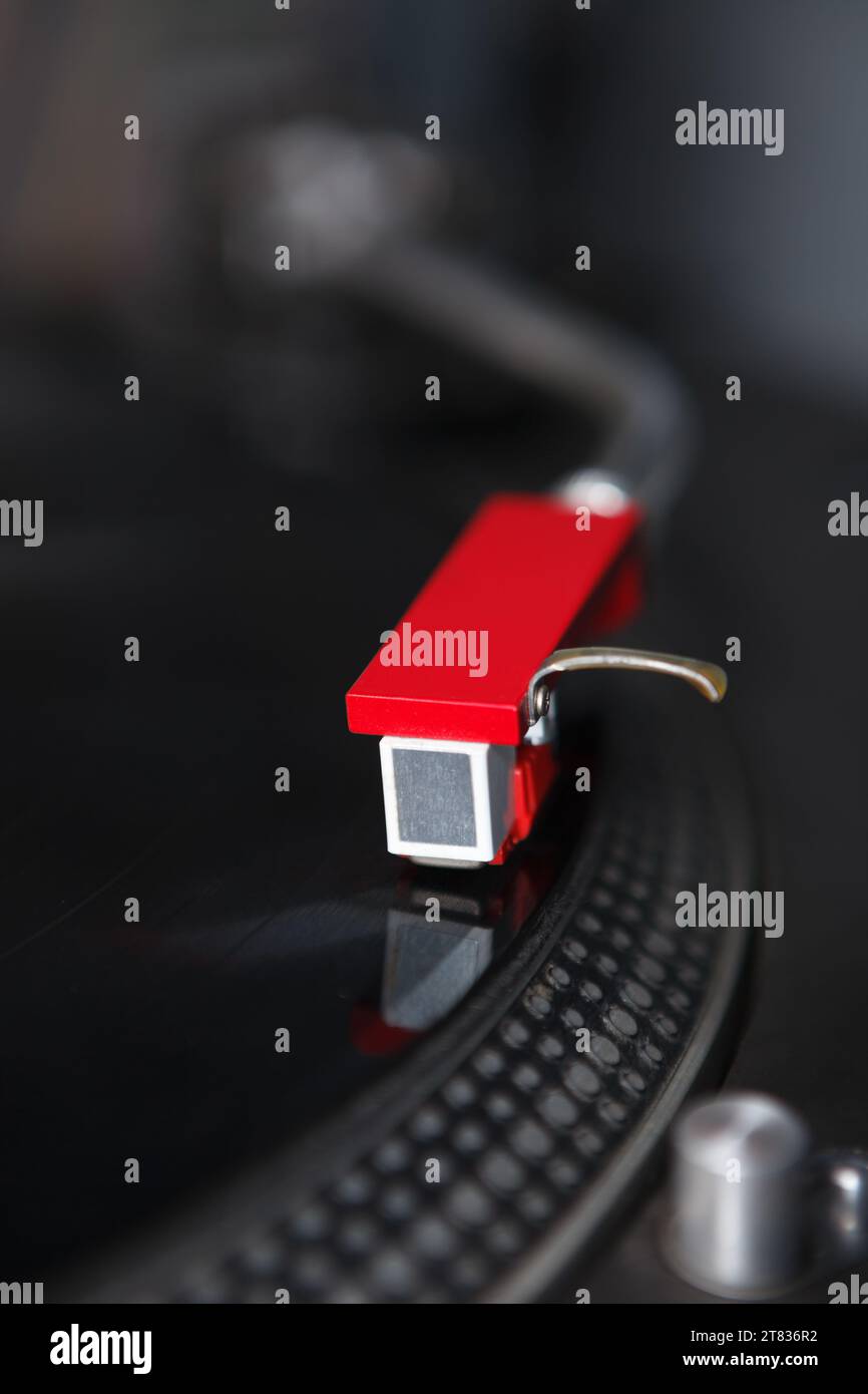 Red needle cartridge on a tonearm of a turntable. Vinyl record player ...