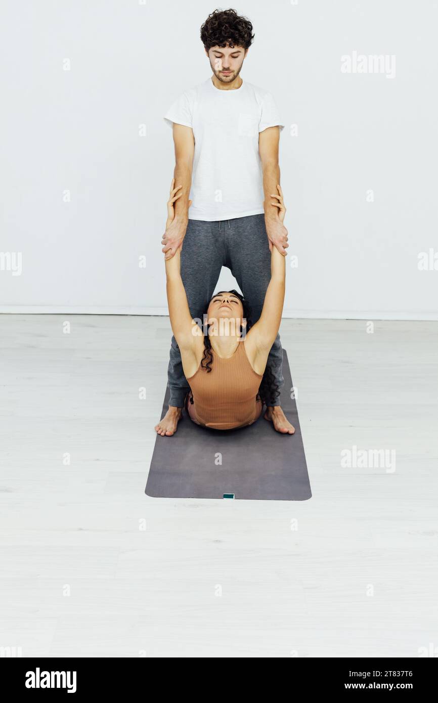 acrobatics yoga poses woman and man do gymnastics warm-up exercises asana flexible body Stock ...