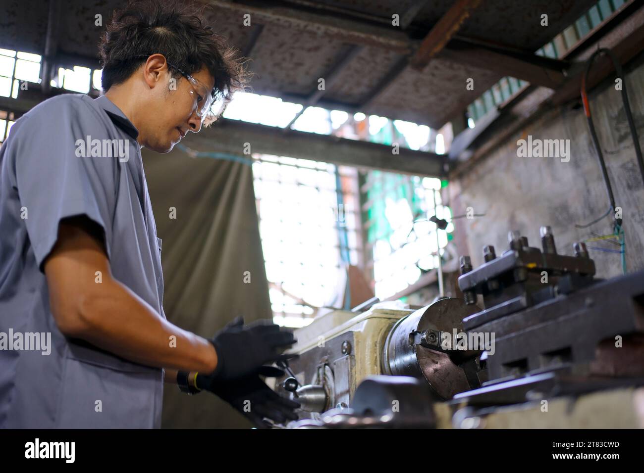 Trainee works at machine shop. Metalwork and education concept Stock ...