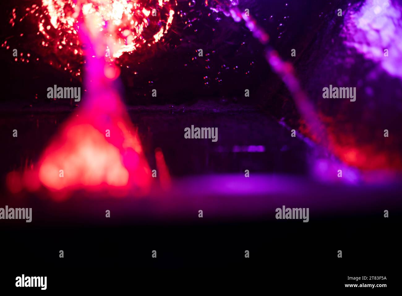 Colored stream of water in the dark. Flow Details. Water illumination ...