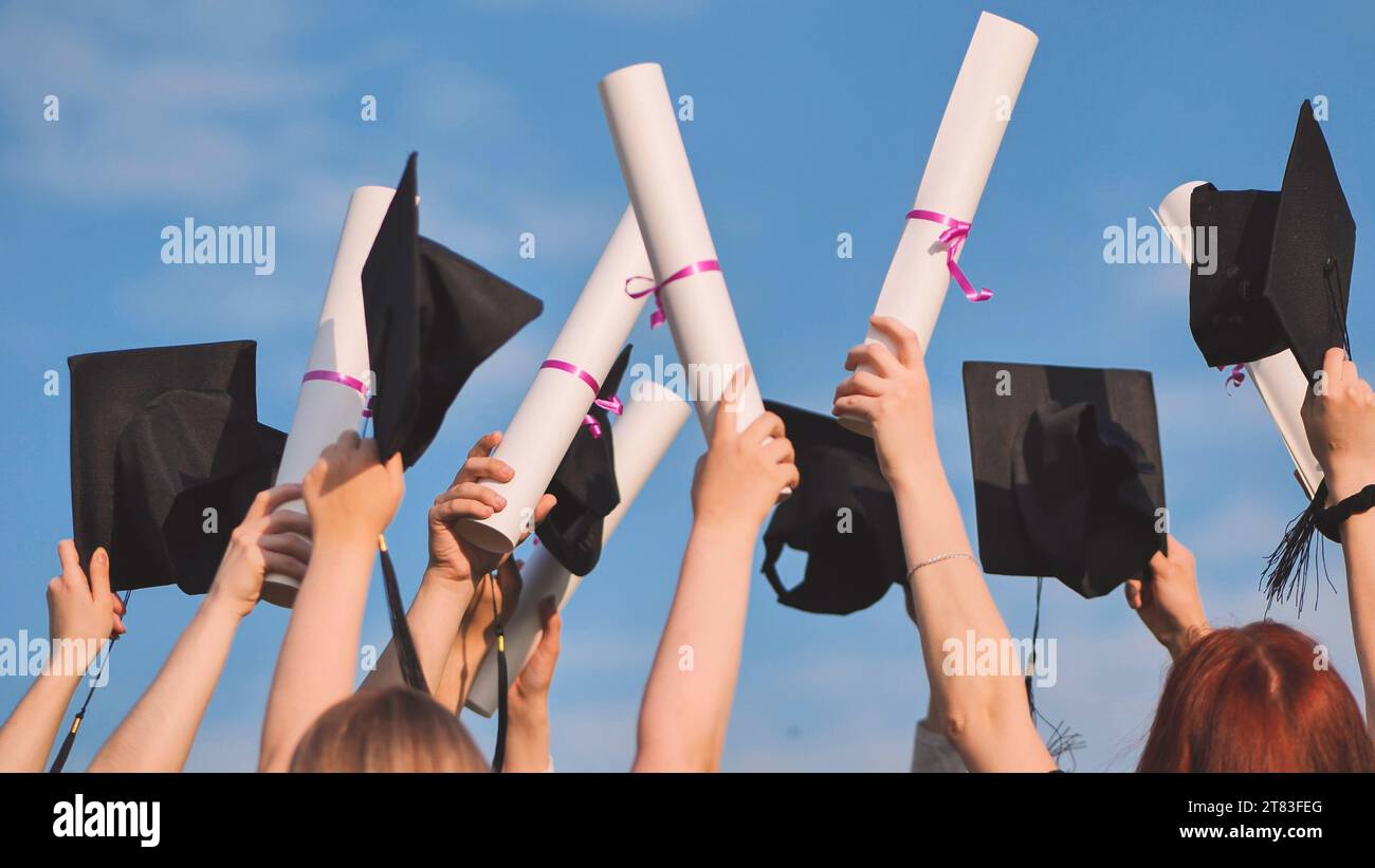 College graduates raise their caps and diplomas upward Stock Photo - Alamy