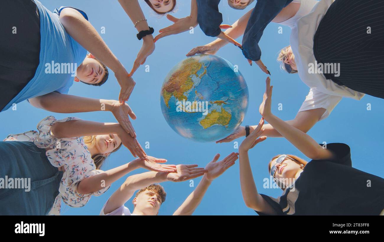 Young boys surround the globe of the world with their palms. The ...