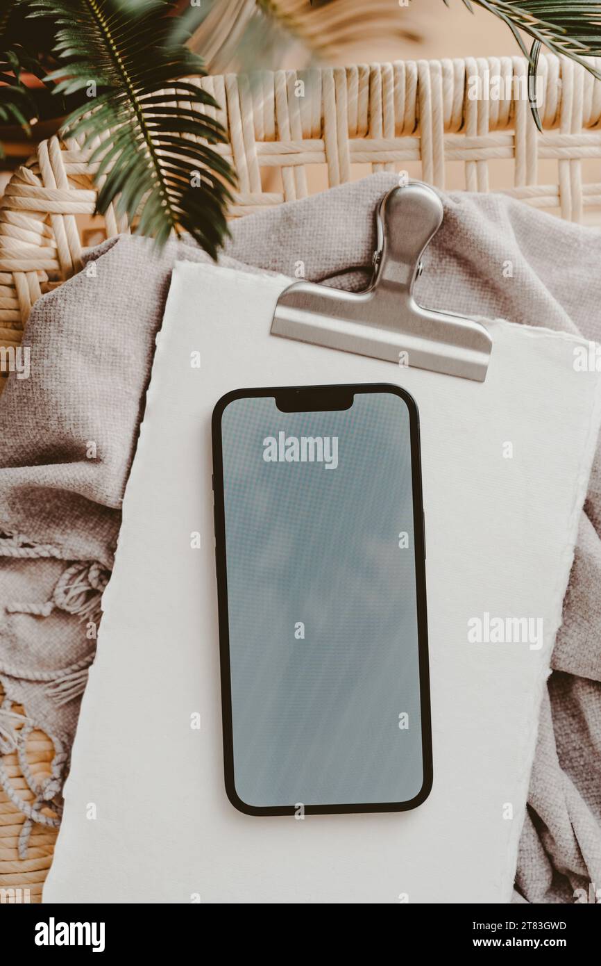 Blank path screen mobile phone with mockup on notepad, near green plant ...