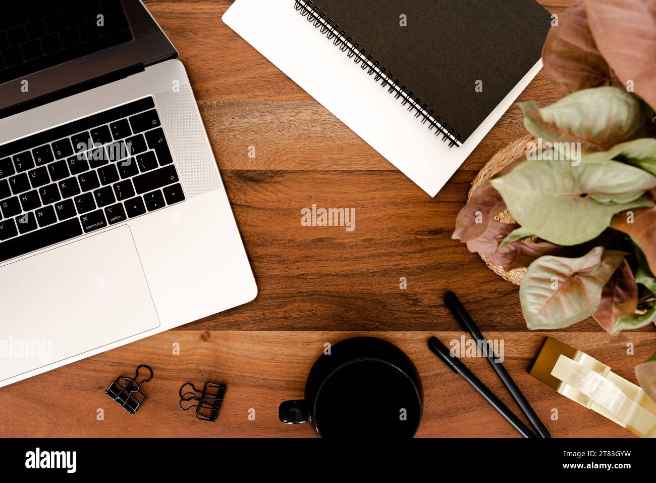 Wood desk office copy space with laptop, stationery and notepads, cup ...