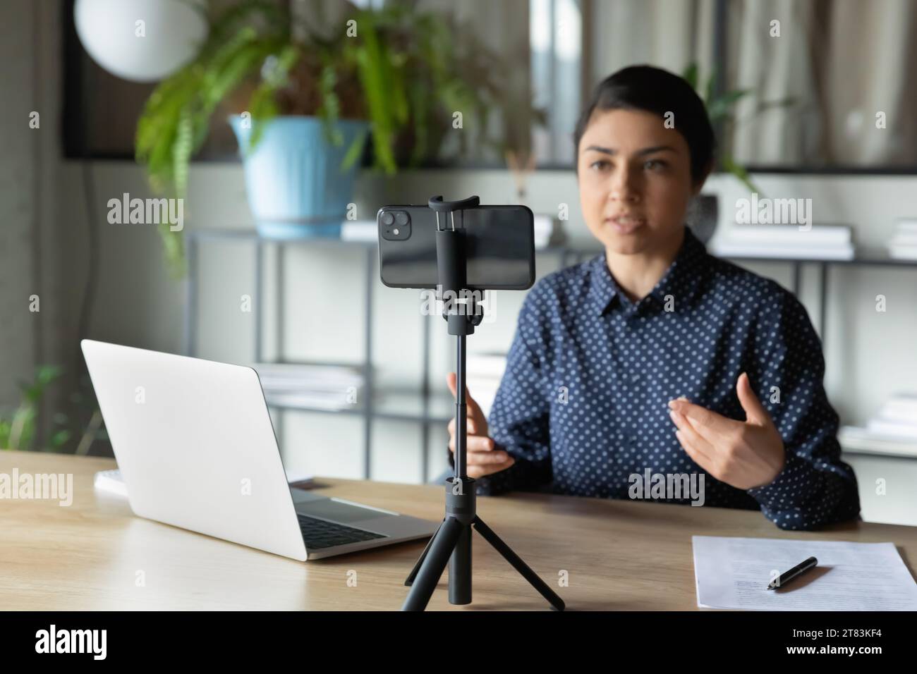 Serious Indian presenter girl, speaker talking at webcam on smartphone ...