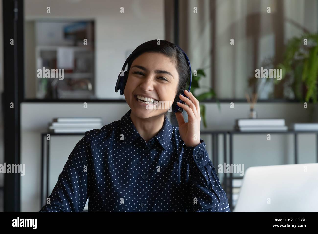 Happy Indian student girl in headphones listening to virtual lecture ...