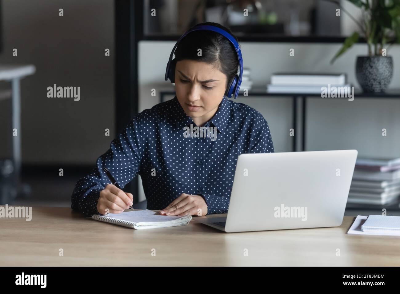 Focused concentrated Indian student in headphones watching webinar on ...