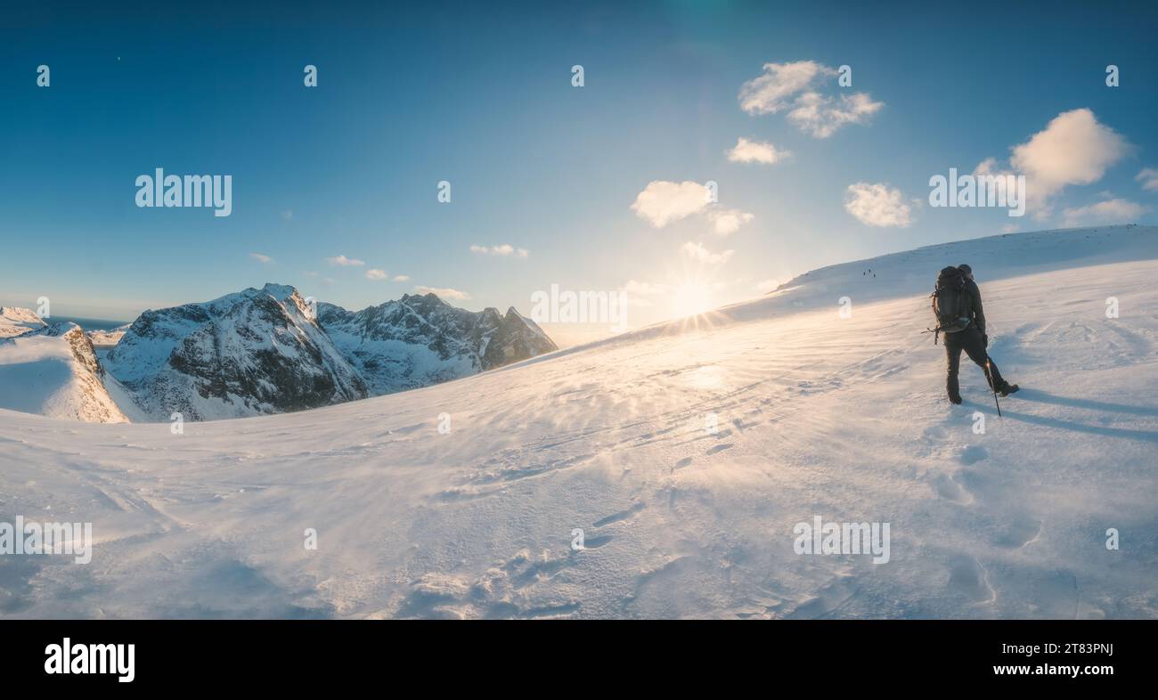Panorama of mountaineer climbing to the top of snowy mountain and ...