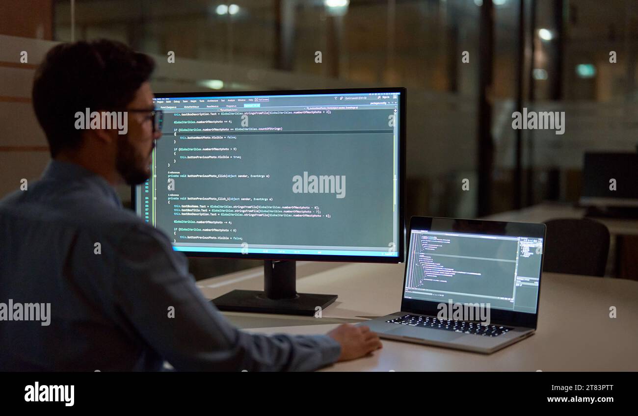 Busy business man software developer working late on computer in dark ...