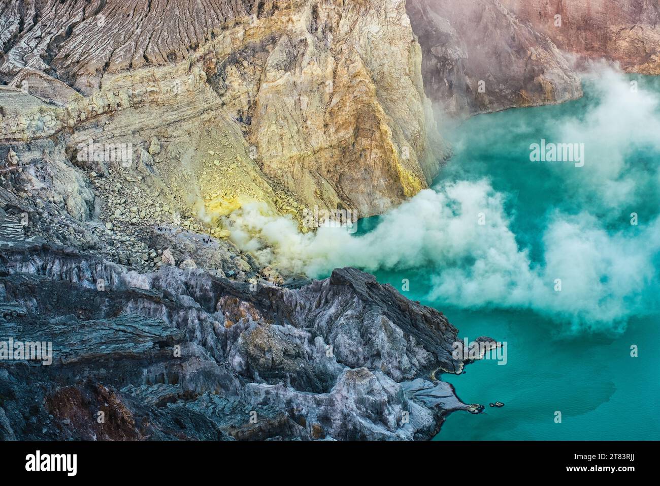 Active volcano with sulphur smoke floating and turquoise lake at Kawah ...