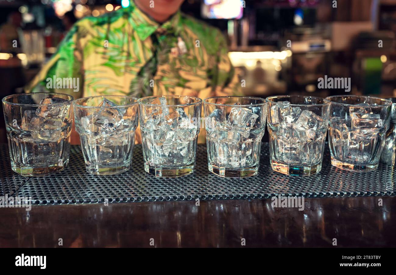 Empty cocktail glass with ice cubes on counter bar in nightclub Stock ...