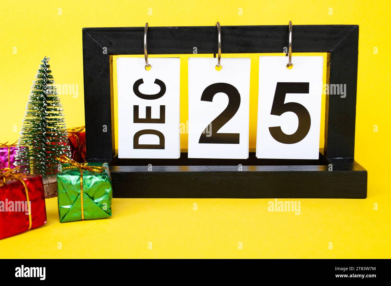 25 December calendar with Christmas tree and presents on yellow ...