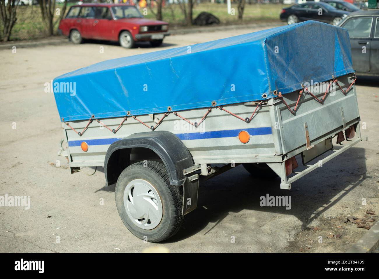Trailer for car. Blue awning on trailer body. Transport in parking lot ...