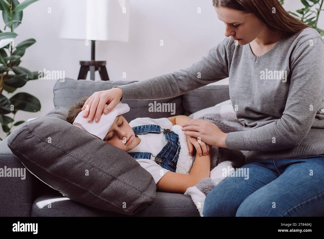 Caring young mother take care of little ill daughter. Sick child has ...