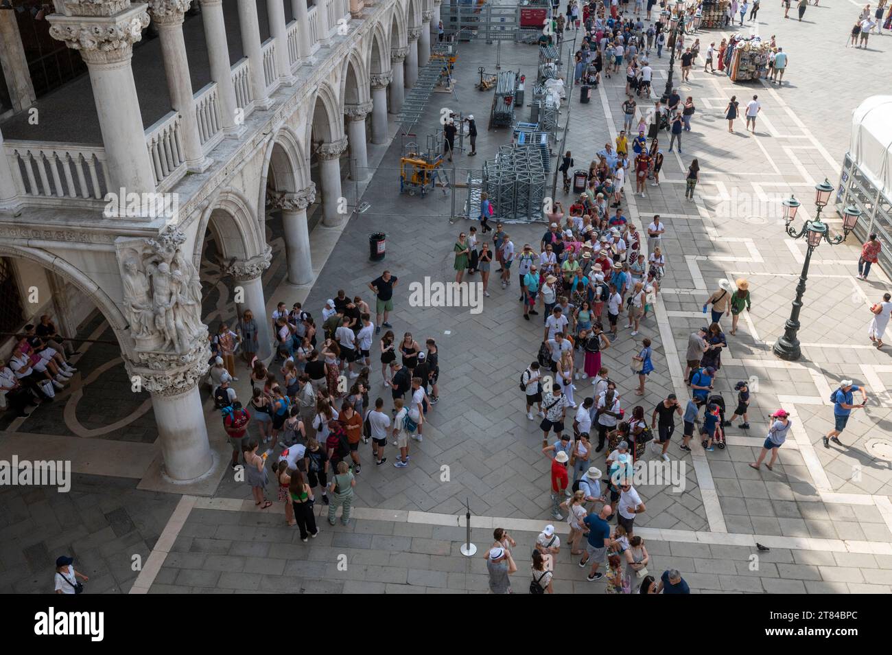 High view of a long queue of tourists and a circle of pre-booked ...