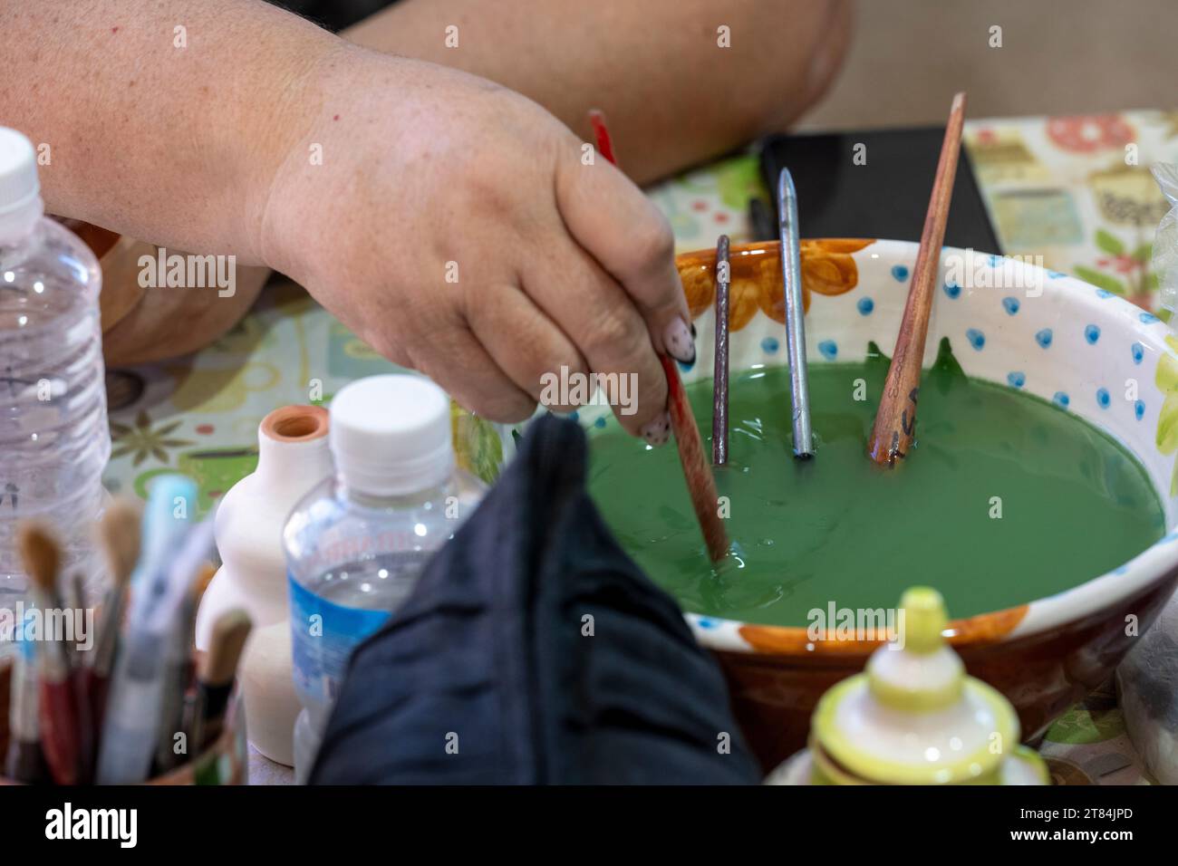 An artisan hand paints traditional Alentejo pottery at Olaria O Patalim ...