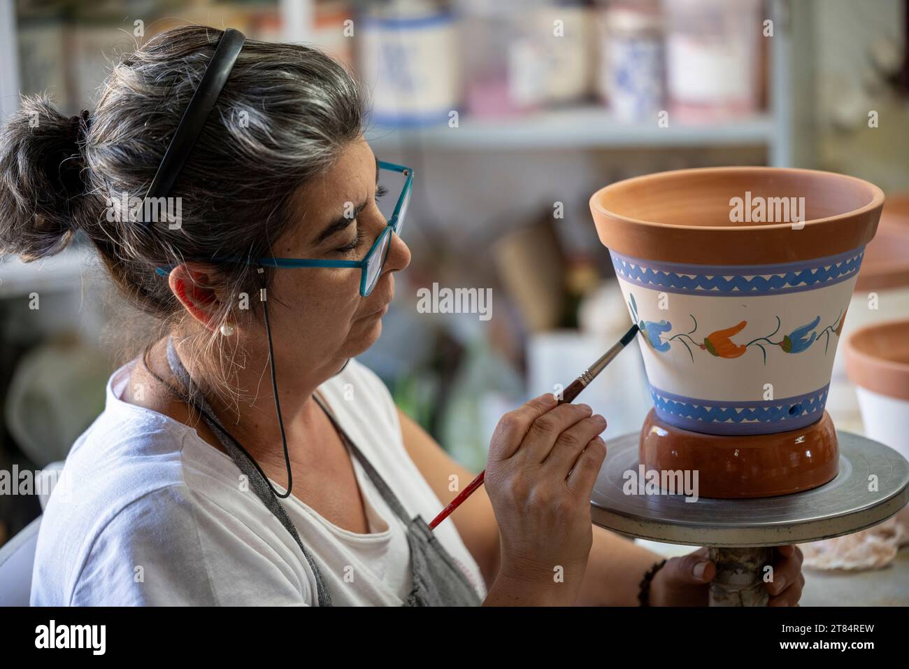 An artisan hand paints traditional Alentejo pottery at Olaria O Patalim ...