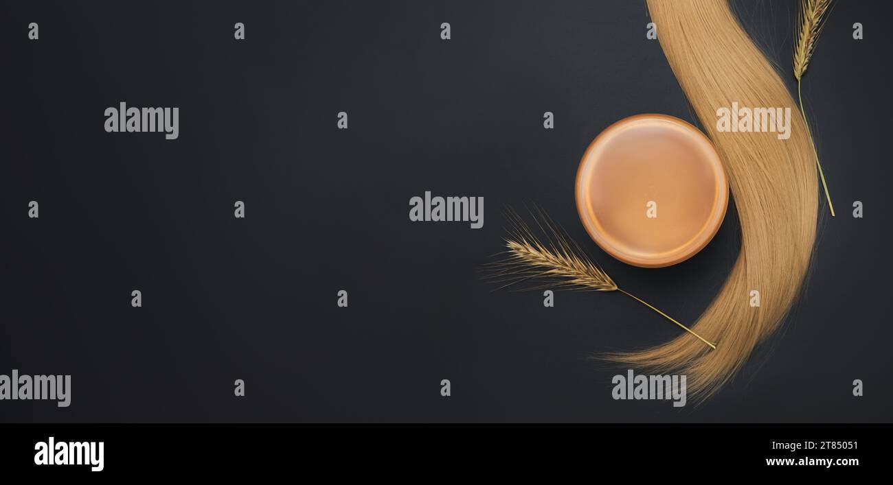 Blond long hair with cream jar and sprigs of ripe wheat. Healthy hair ...