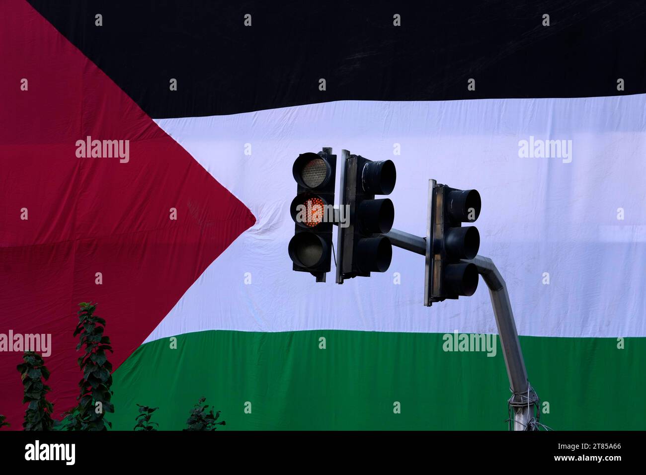 Traffic lights are seen in front of a huge Palestinian flag which hangs ...