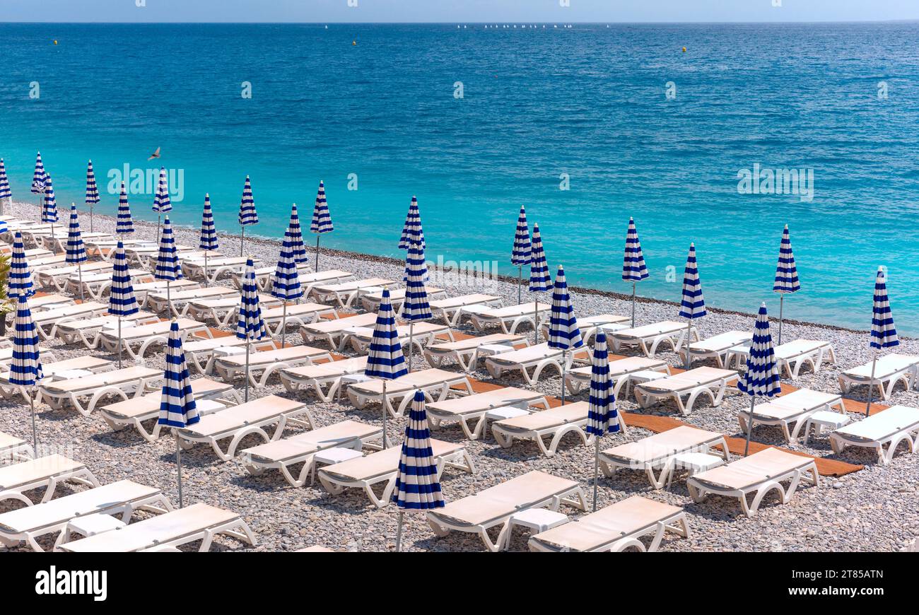 Parasols on beach of Nice in sunny summer day with blue sky, Nice ...