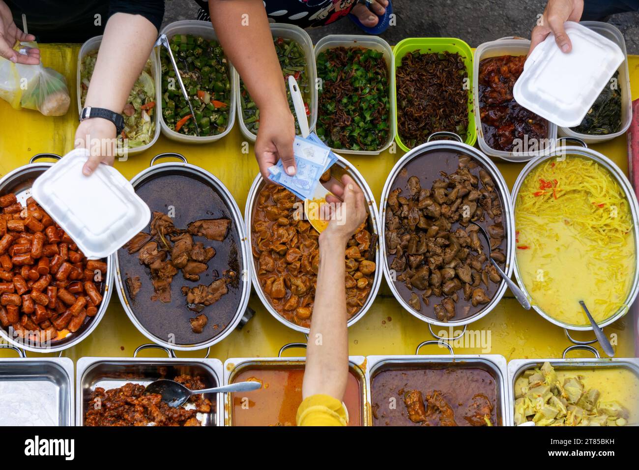 Paying for food at Kota Kinabalu Street Market Stock Photo - Alamy