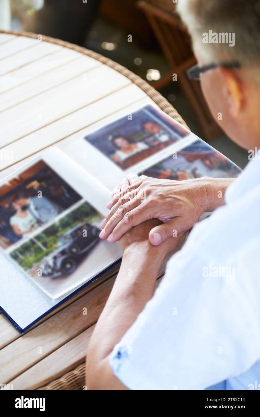 Photo album, photograph and senior man for memory, reflection and nostalgia in home. Family ...