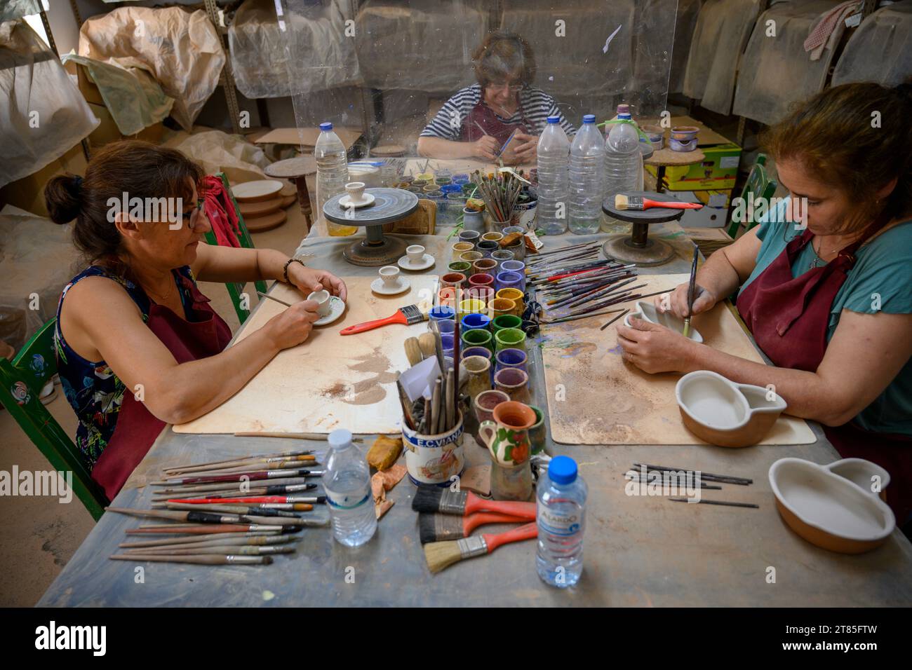 An artisan hand paints traditional Alentejo pottery at a Pottery ...