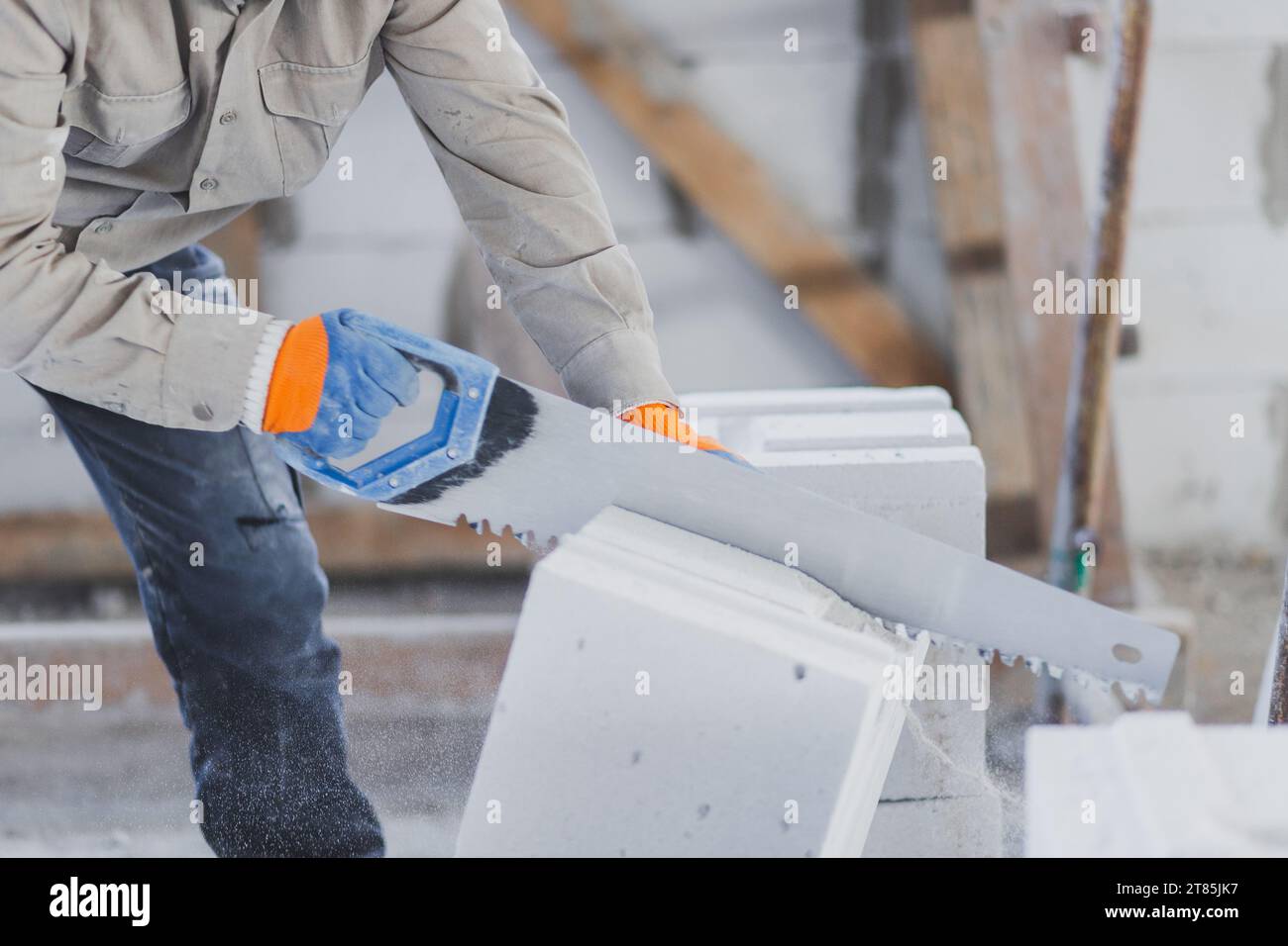 Sawing an autoclaved aerated block with a hand saw at a construction ...