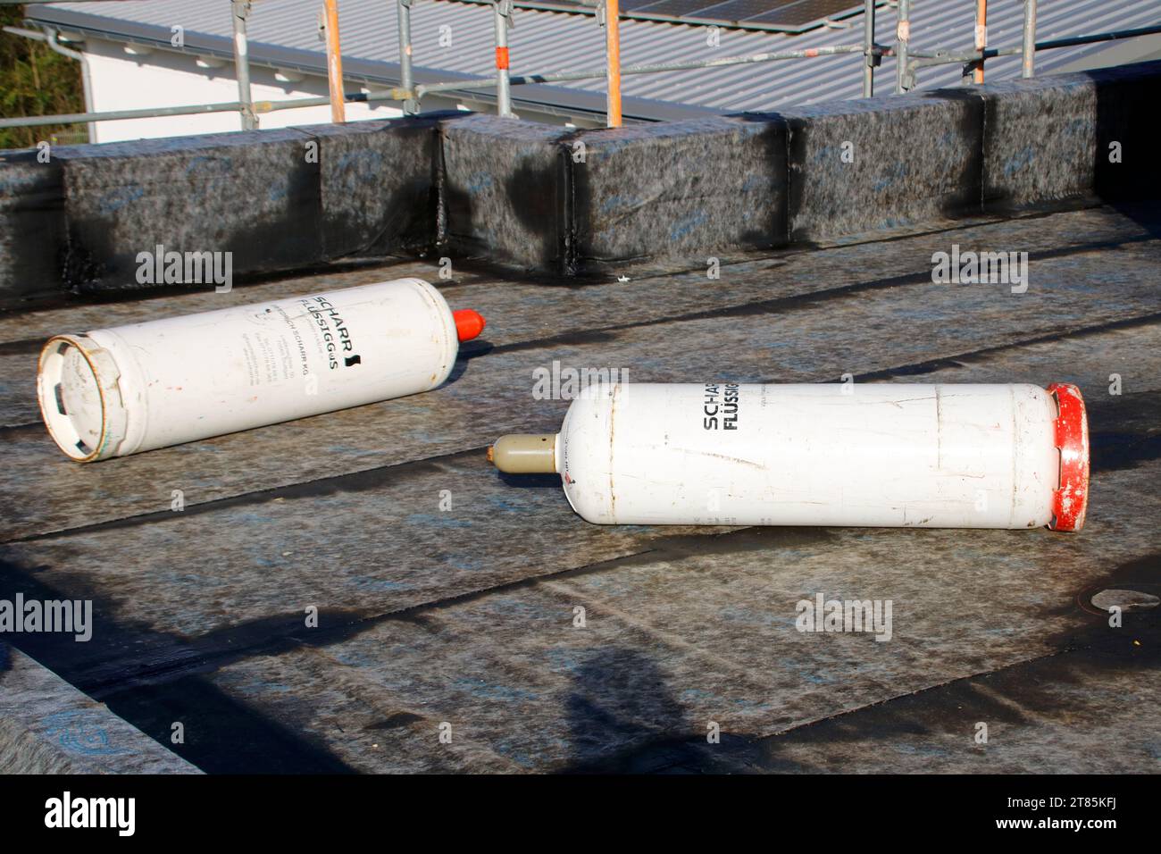 Gas bottles are lying on a house roof while working Stock Photo - Alamy
