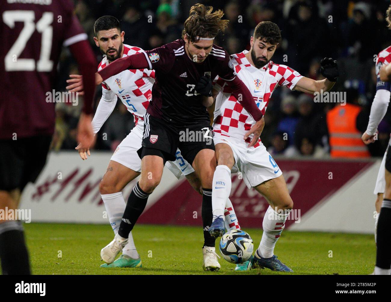 Latvia's Roberts Uldrikis, center, challenges for the ball with Latvia ...