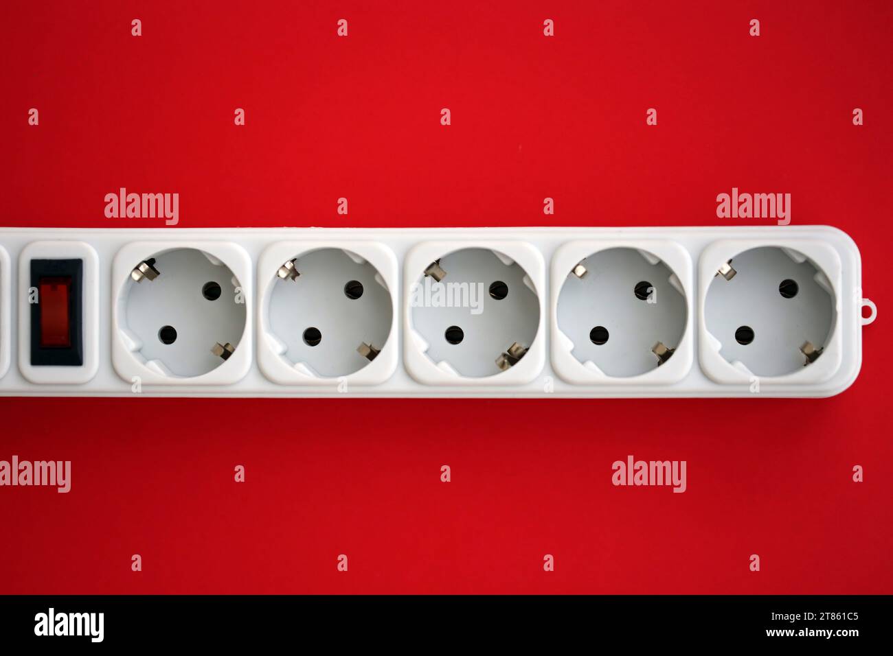 White electrical multi plug extender with european socket on bright red ...