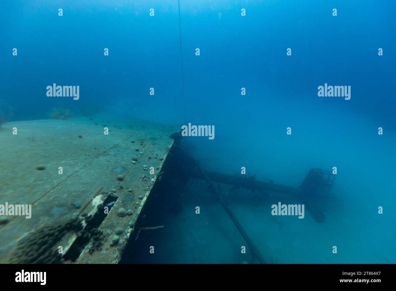 Hull of an old cargo vessel shipwreck lays on it's side in the sandy ...