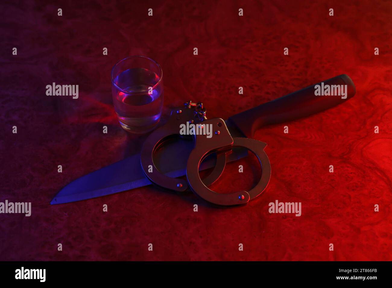 Glass with vodka alcohol drink, knife and handcuffs. Concept of ...
